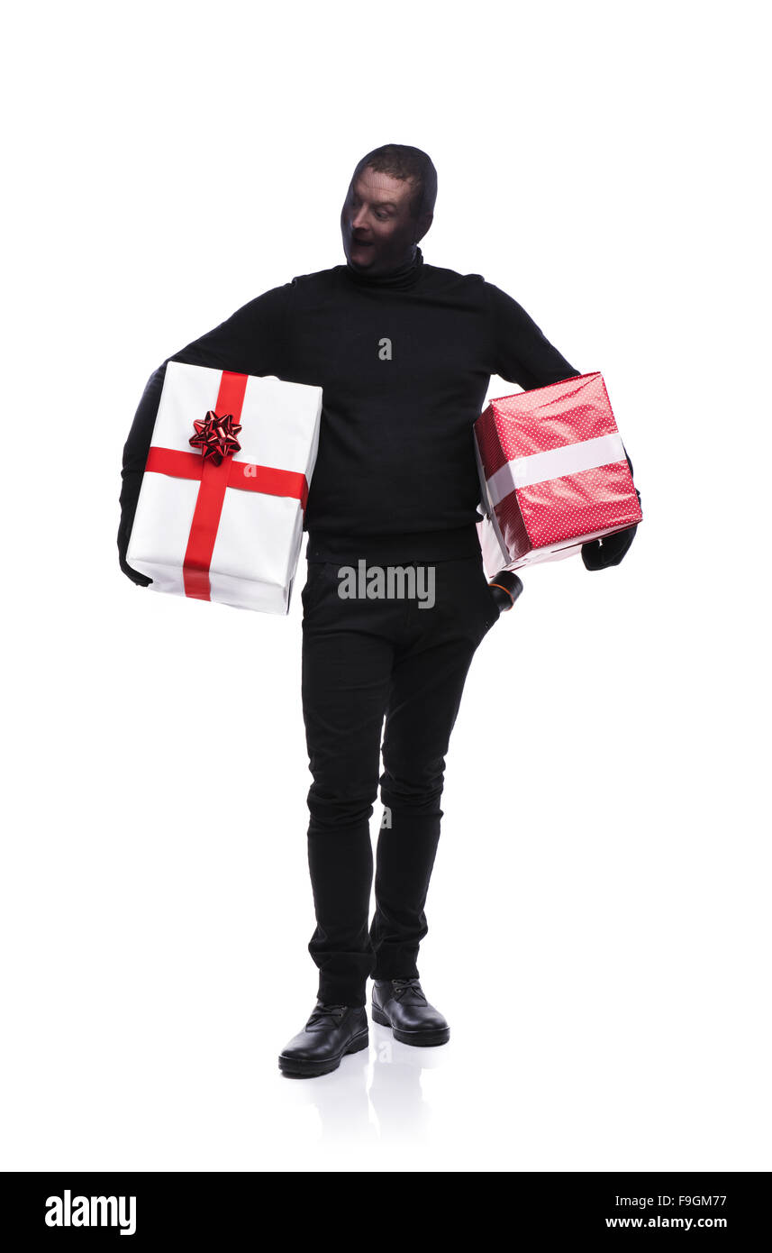 Thief in action carrying presents with balaclava on his face, dressed ...
