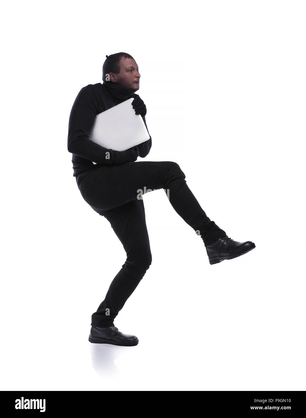 Thief in action stealing information with balaclava on his face ...