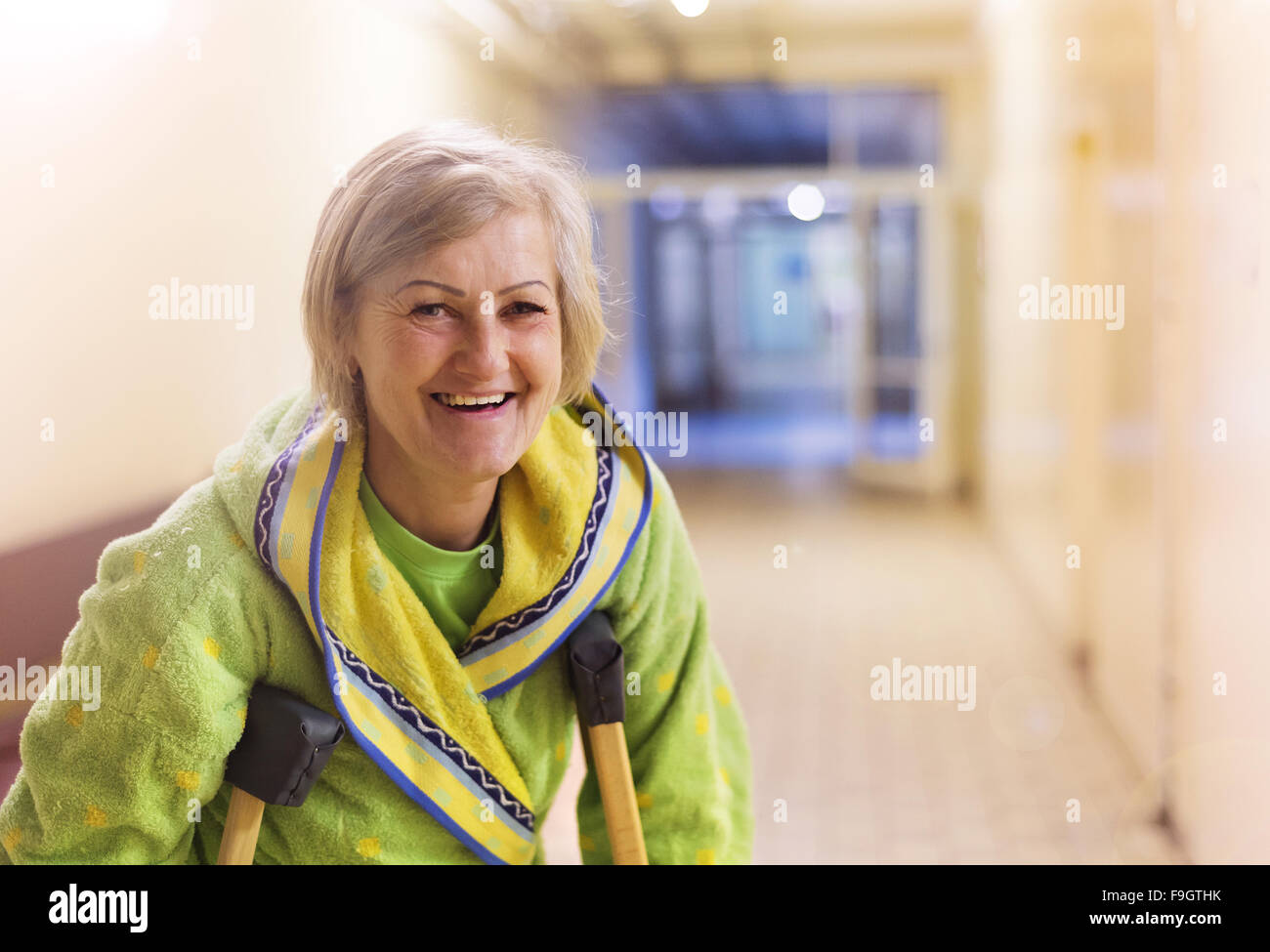 Senior woman injured sitting in the hallway of hospital holding ...