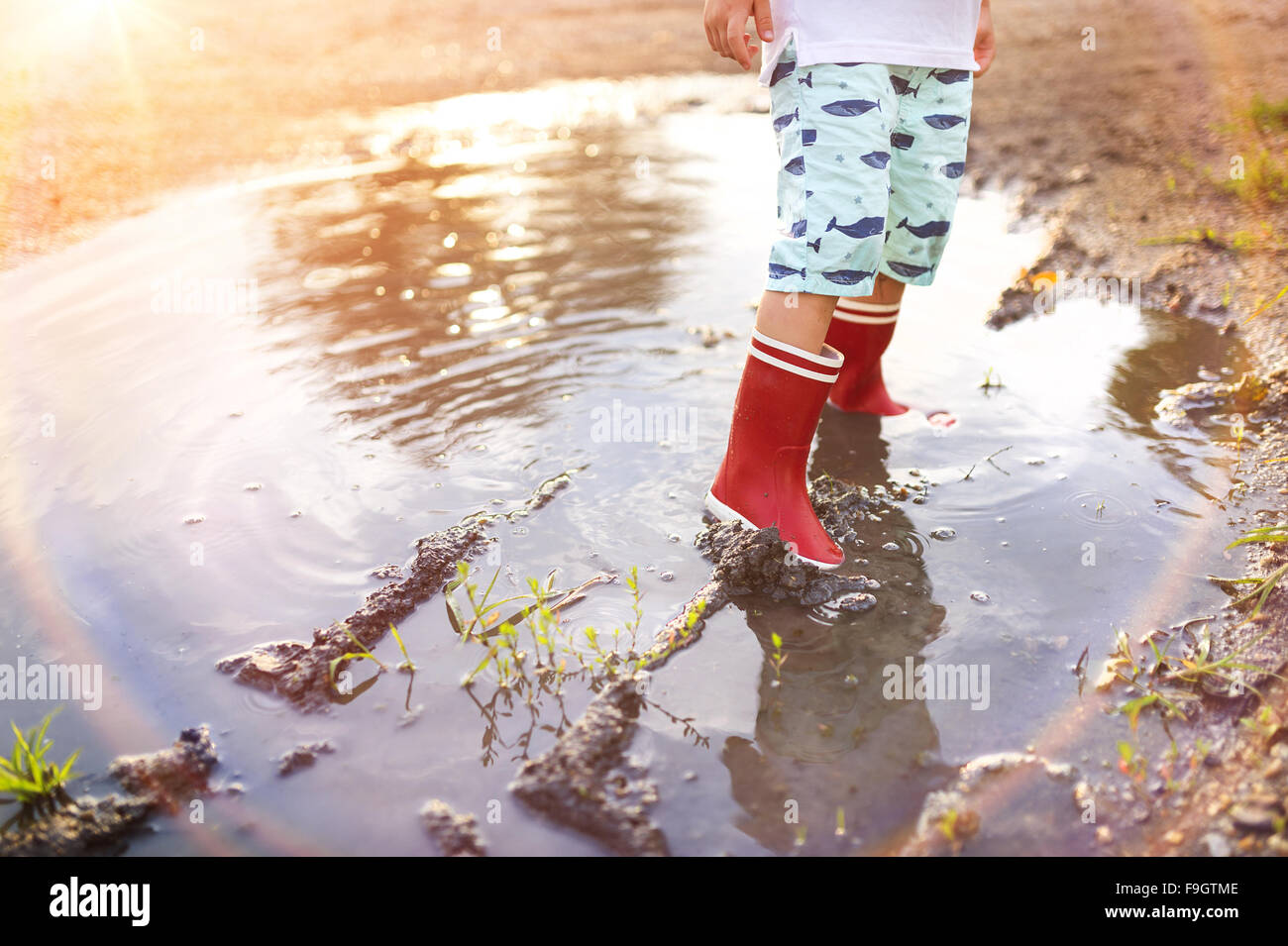 Little boy playing outside in a puddle Stock Photo - Alamy