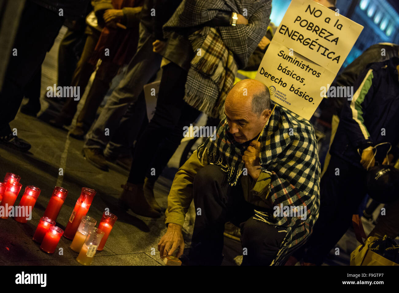 A man lighting a candle with a banner that reads "No to energy poverty ...
