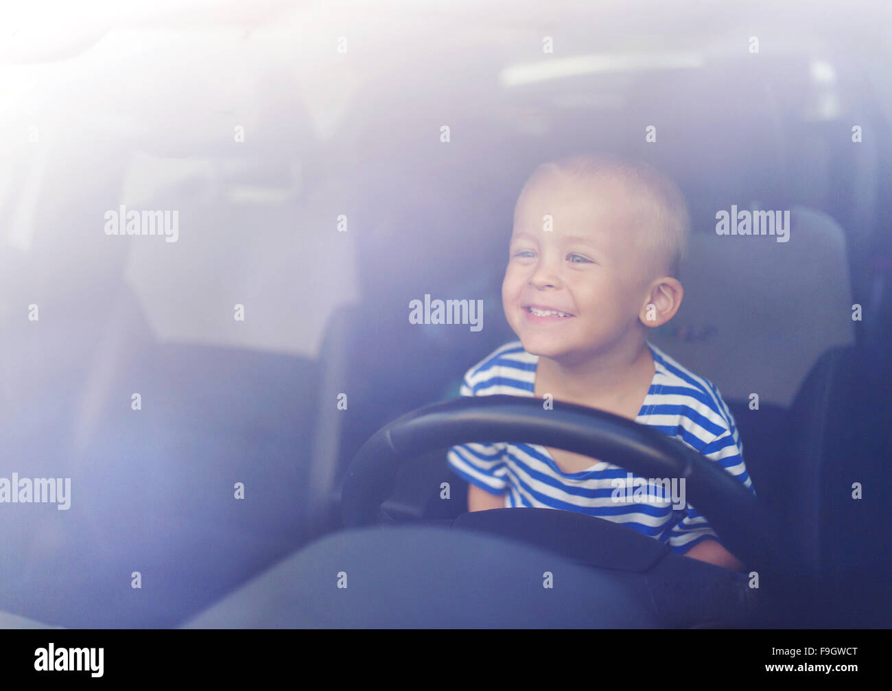 Little boy playing with a steering wheel in a car Stock Photo - Alamy