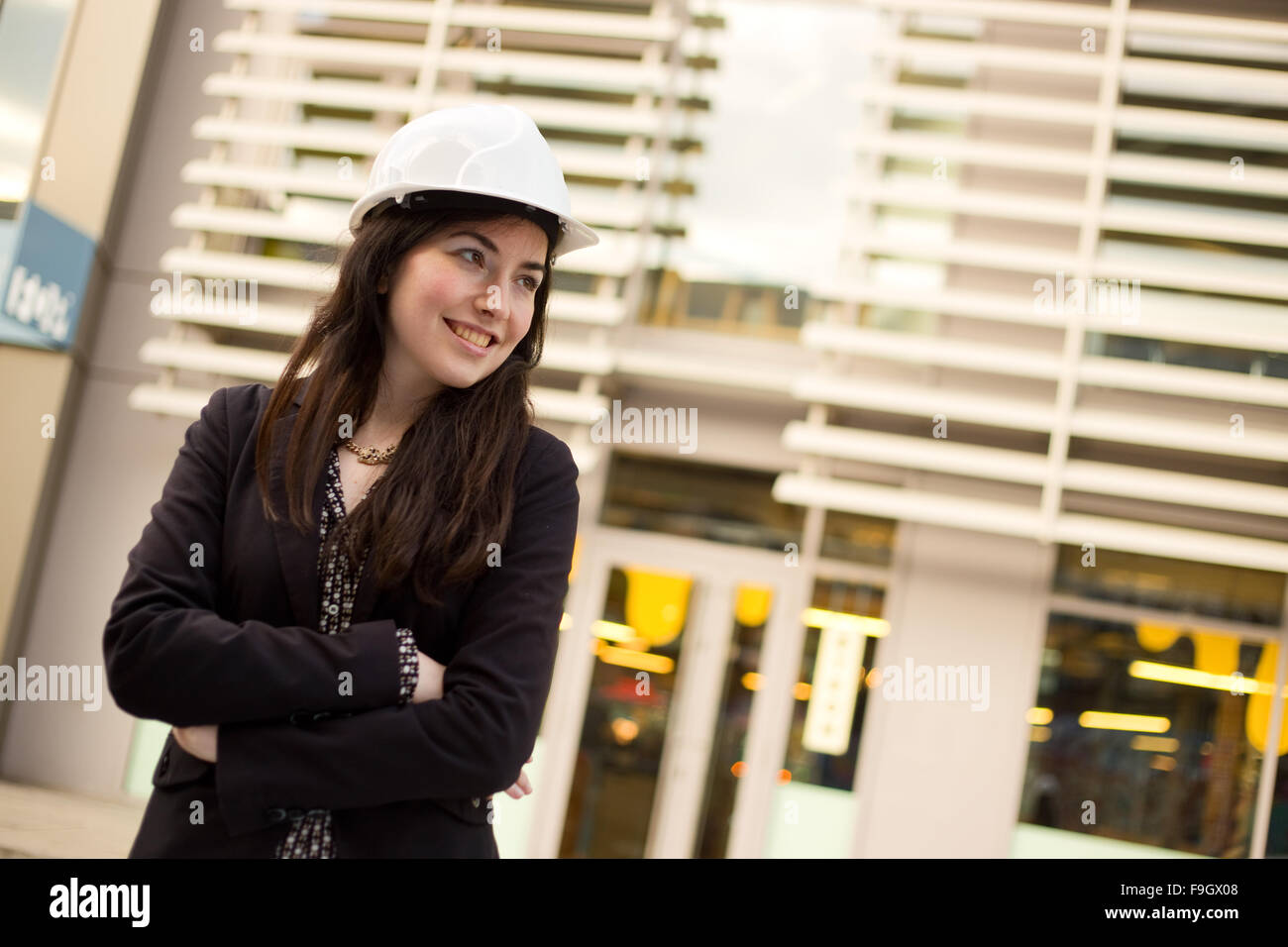 young woman wearing a construction hard hat with an architecture ...