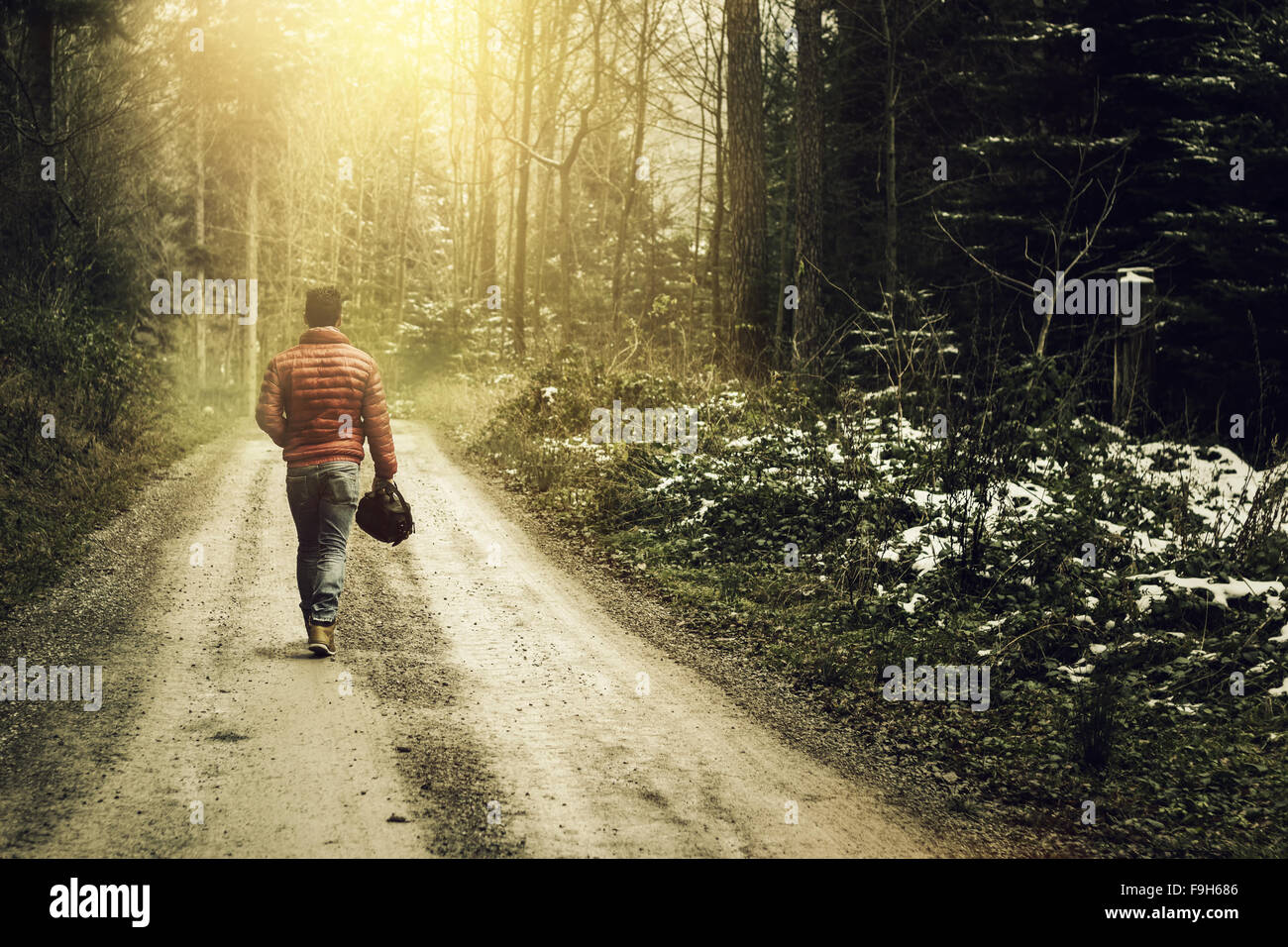 Nature footpath through snowy forest and walking alone man against fog ...