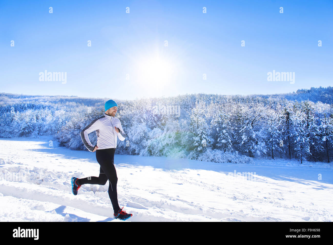 Young sportsman jogging outside in sunny winter park Stock Photo - Alamy