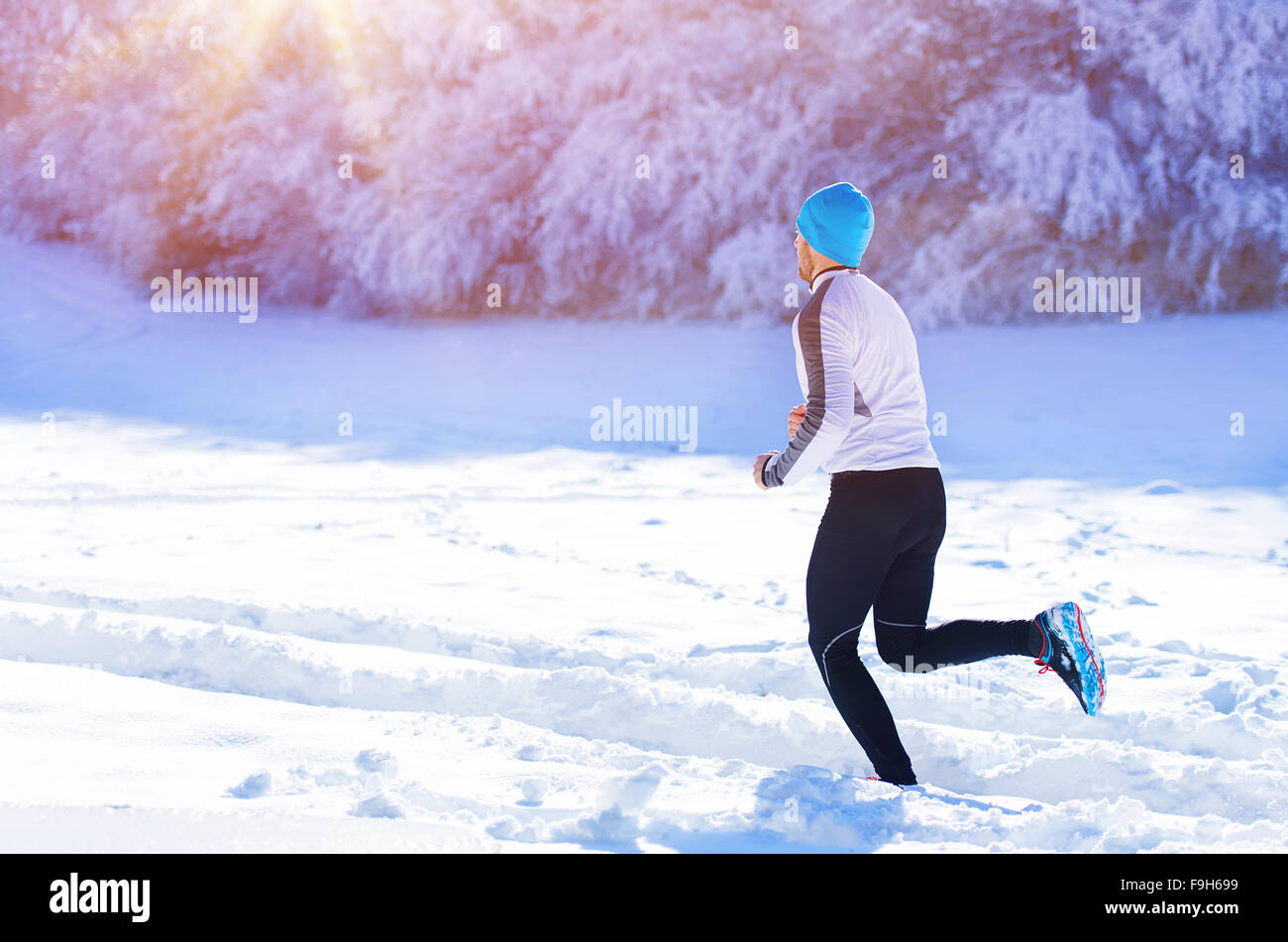 Young sportsman jogging outside in sunny winter park Stock Photo - Alamy