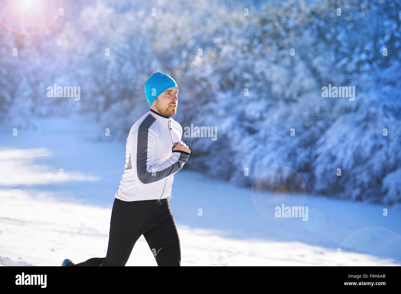 Young sportsman jogging outside in sunny winter park Stock Photo - Alamy