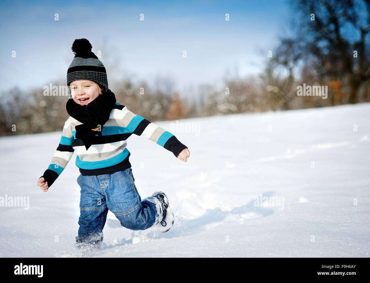 Cute little boy playing outside in the snow in winter Stock Photo - Alamy