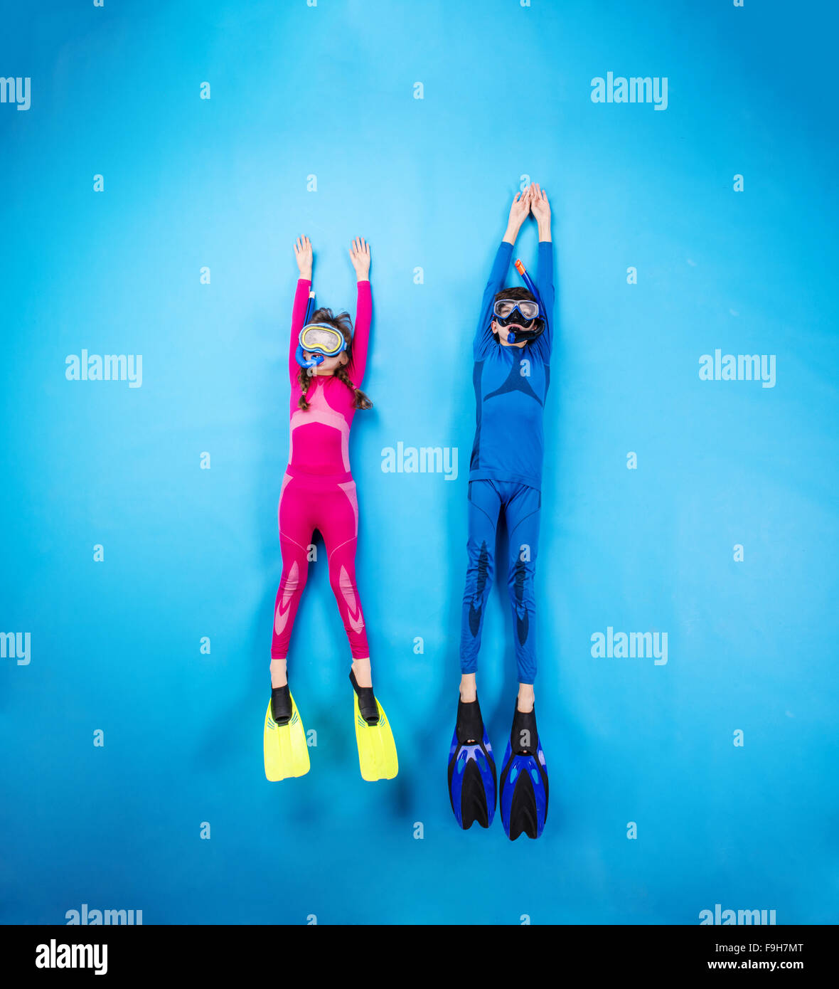 Children scuba diving deep in the sea. Studio shot on a blue background ...