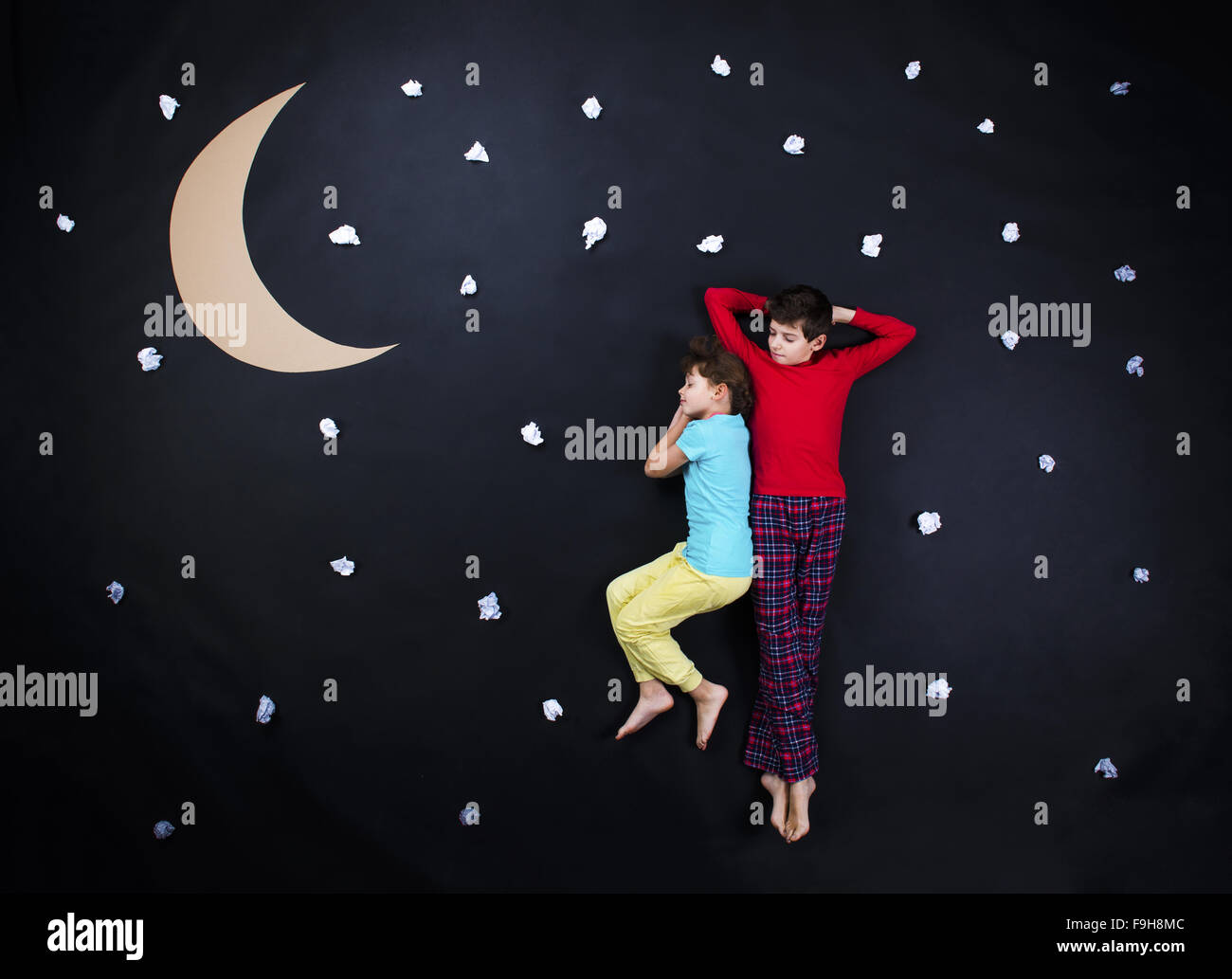 Children getting ready for bedtime. Studio shot on a black background ...