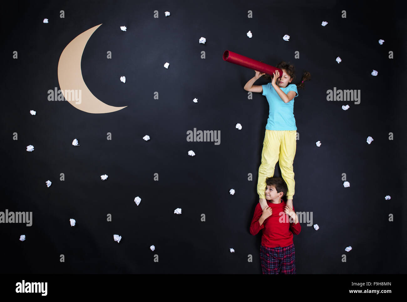 Children getting ready for bedtime. Studio shot on a black background ...
