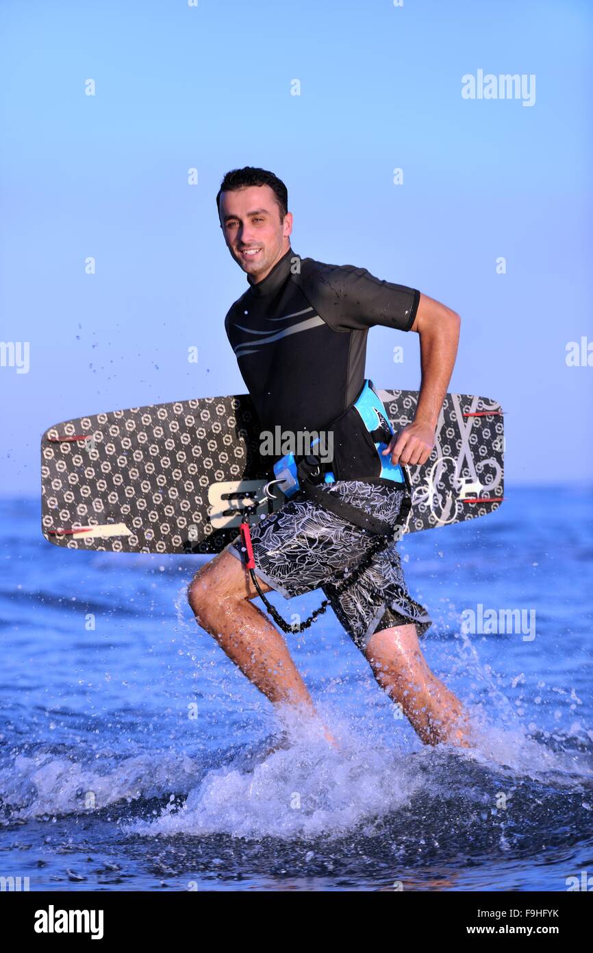 Portrait of a strong young surf man at beach on sunset in a ...