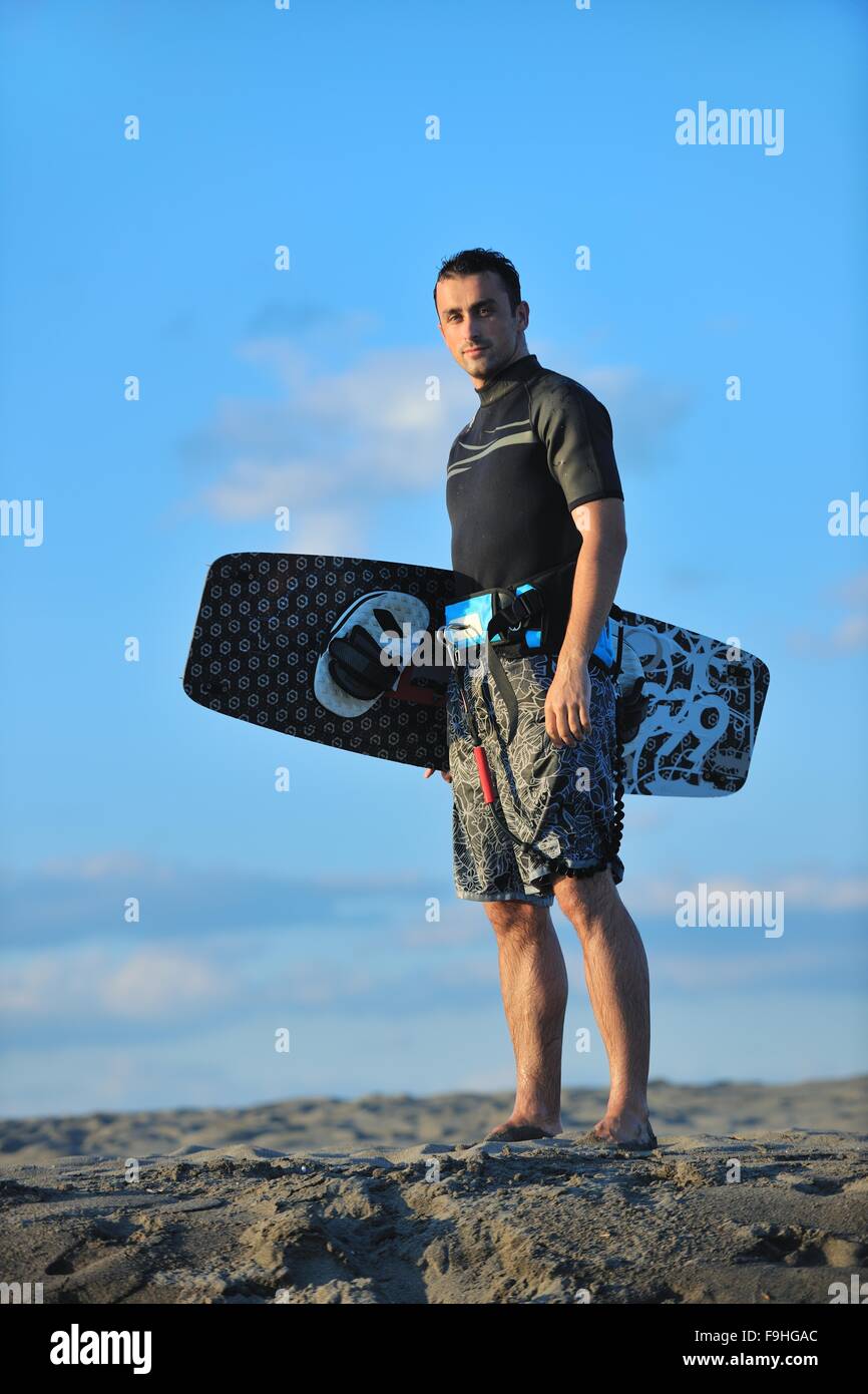Portrait of a strong young surf man at beach on sunset in a ...