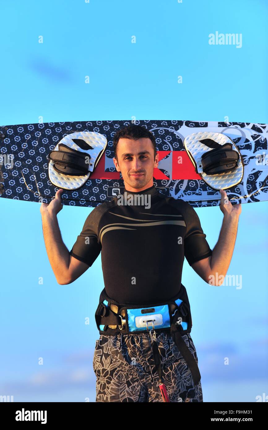 Portrait of a strong young surf man at beach on sunset in a ...