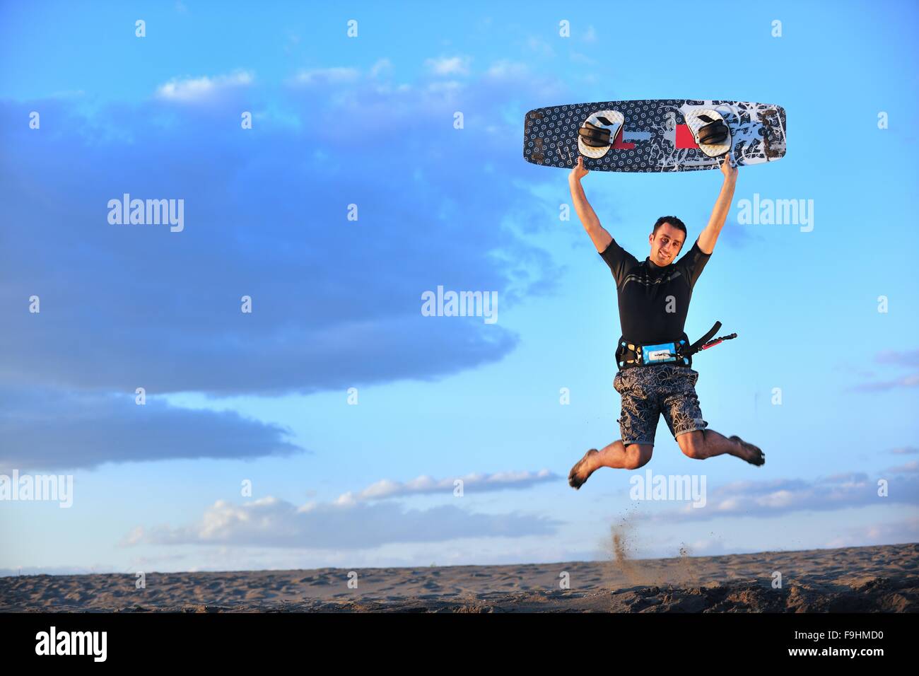 Portrait of a strong young surf man at beach on sunset in a ...