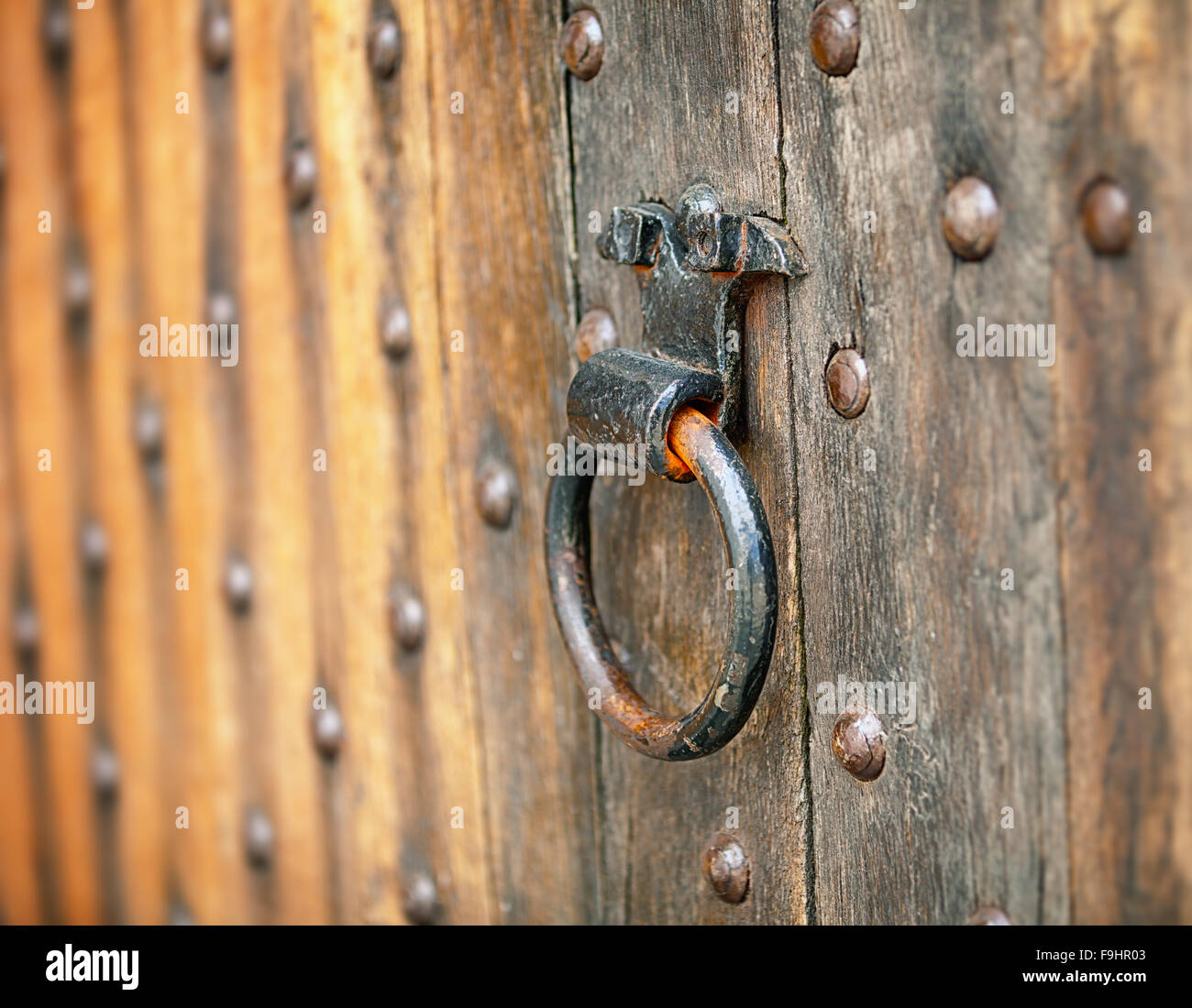 Close up of an old rusty metal ring on a medieval style timber door ...