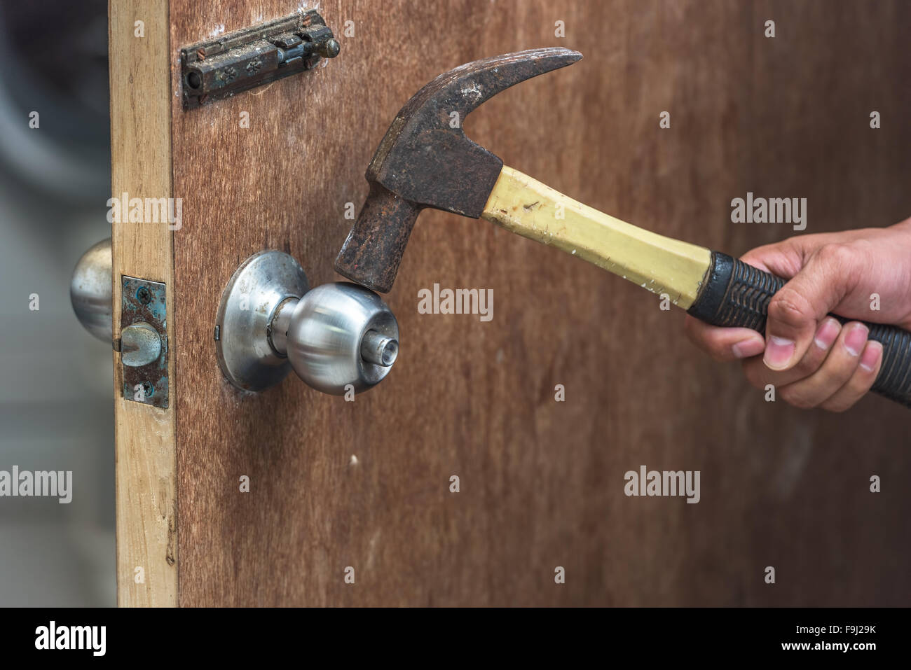 Thief with of hammer in the hand to open a door Stock Photo - Alamy