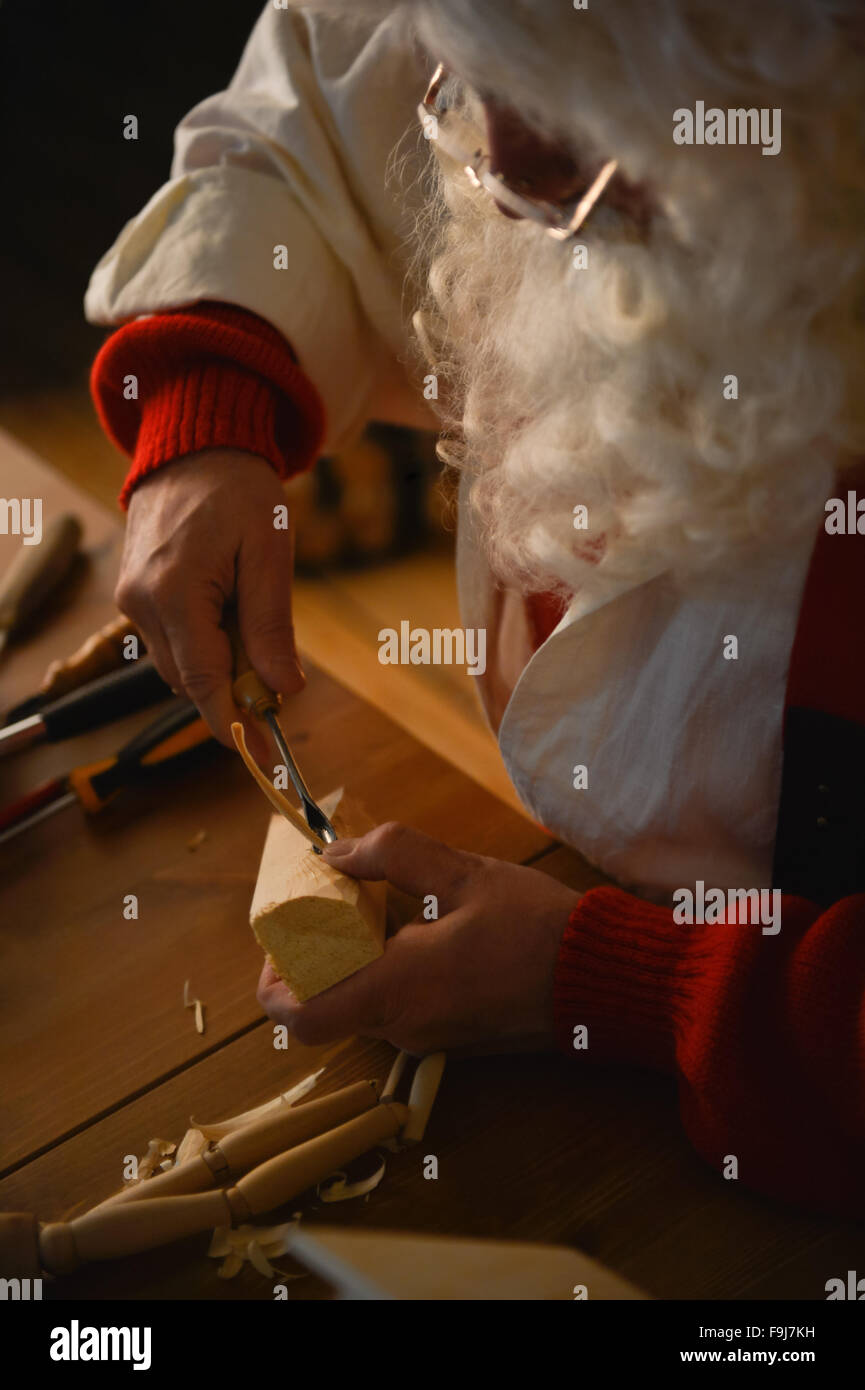 Santa Claus at Home carving something from wooden plank Stock Photo - Alamy