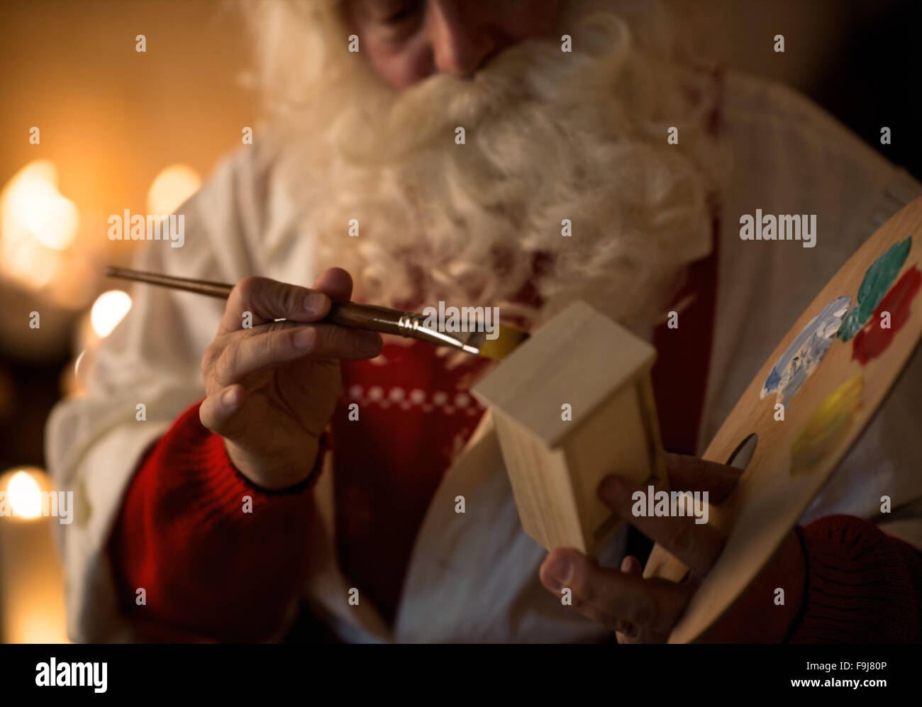 Santa Claus at Home making toys and painting Stock Photo - Alamy
