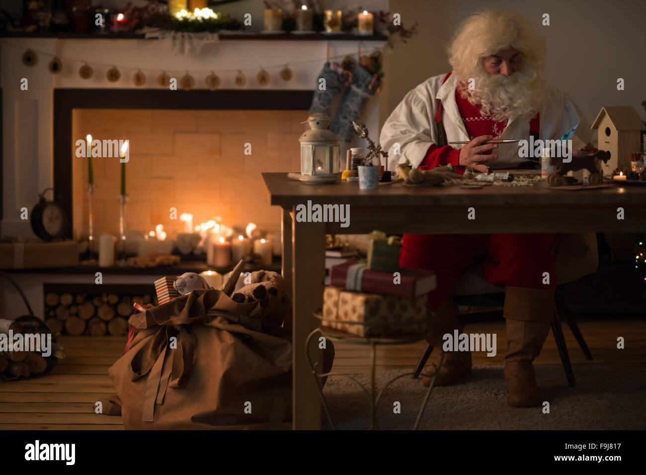 Santa Claus at Home making toys and painting Stock Photo - Alamy
