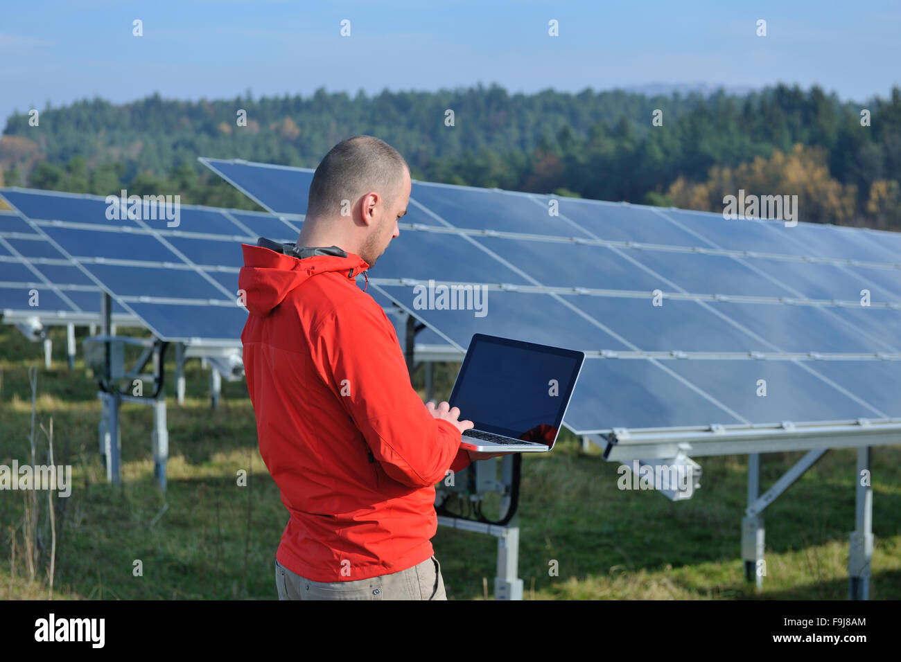 business man engineer using laptop at solar panels plant eco energy ...