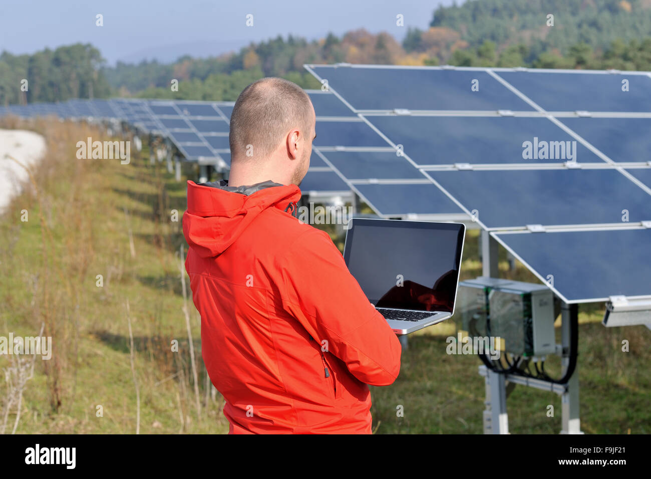 business man engineer using laptop at solar panels plant eco energy ...