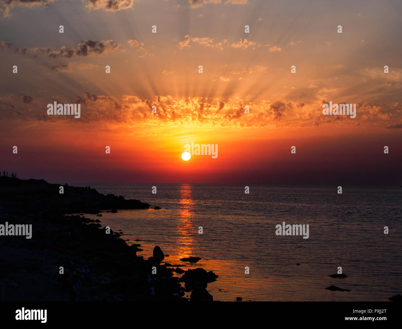 The setting sun on the background of the sea surface and sea beach ...