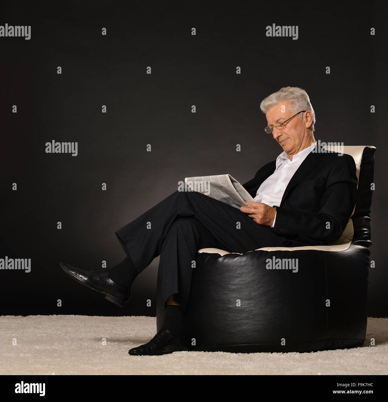 Mature man sitting with newspaper Stock Photo - Alamy