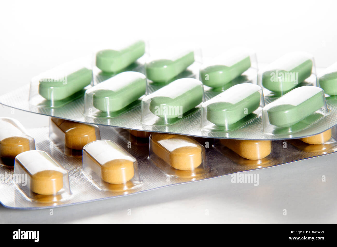 green and yellow tablets in a plastic packaging Stock Photo - Alamy