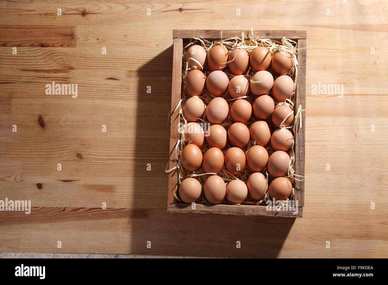 bunch of fresh brown eggs and some straw in a wooden crate Stock Photo ...