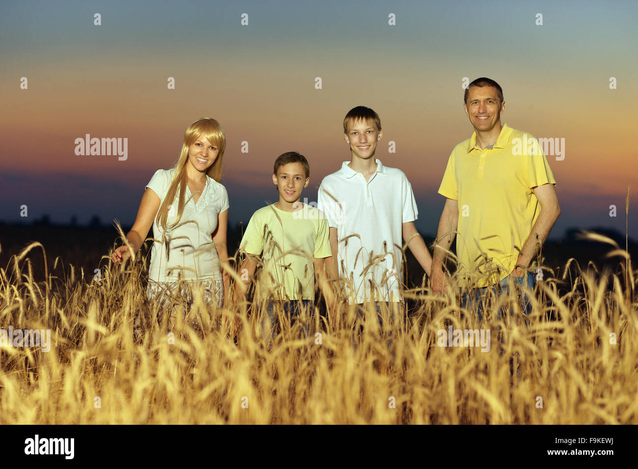 Happy family in wheat field Stock Photo - Alamy