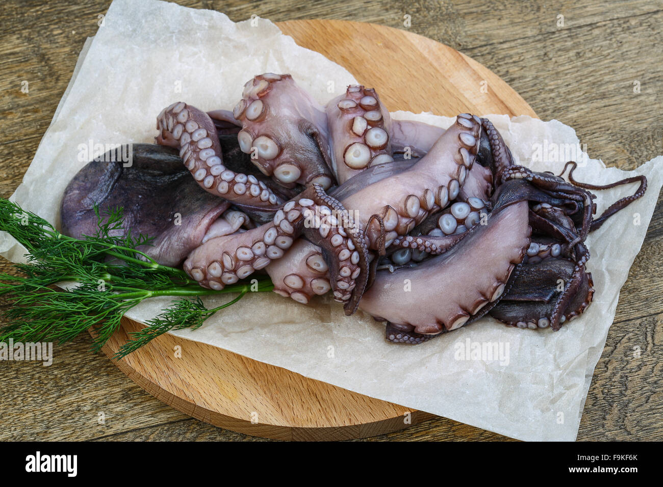 Raw octopus on the wood background ready for cooking Stock Photo - Alamy