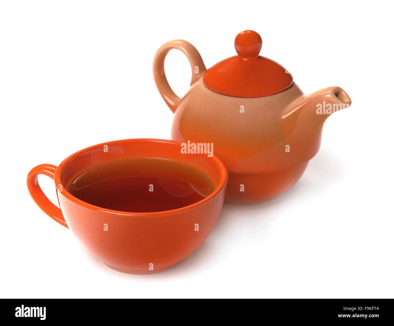 Orange cup of tea and teapot on a white background Stock Photo - Alamy