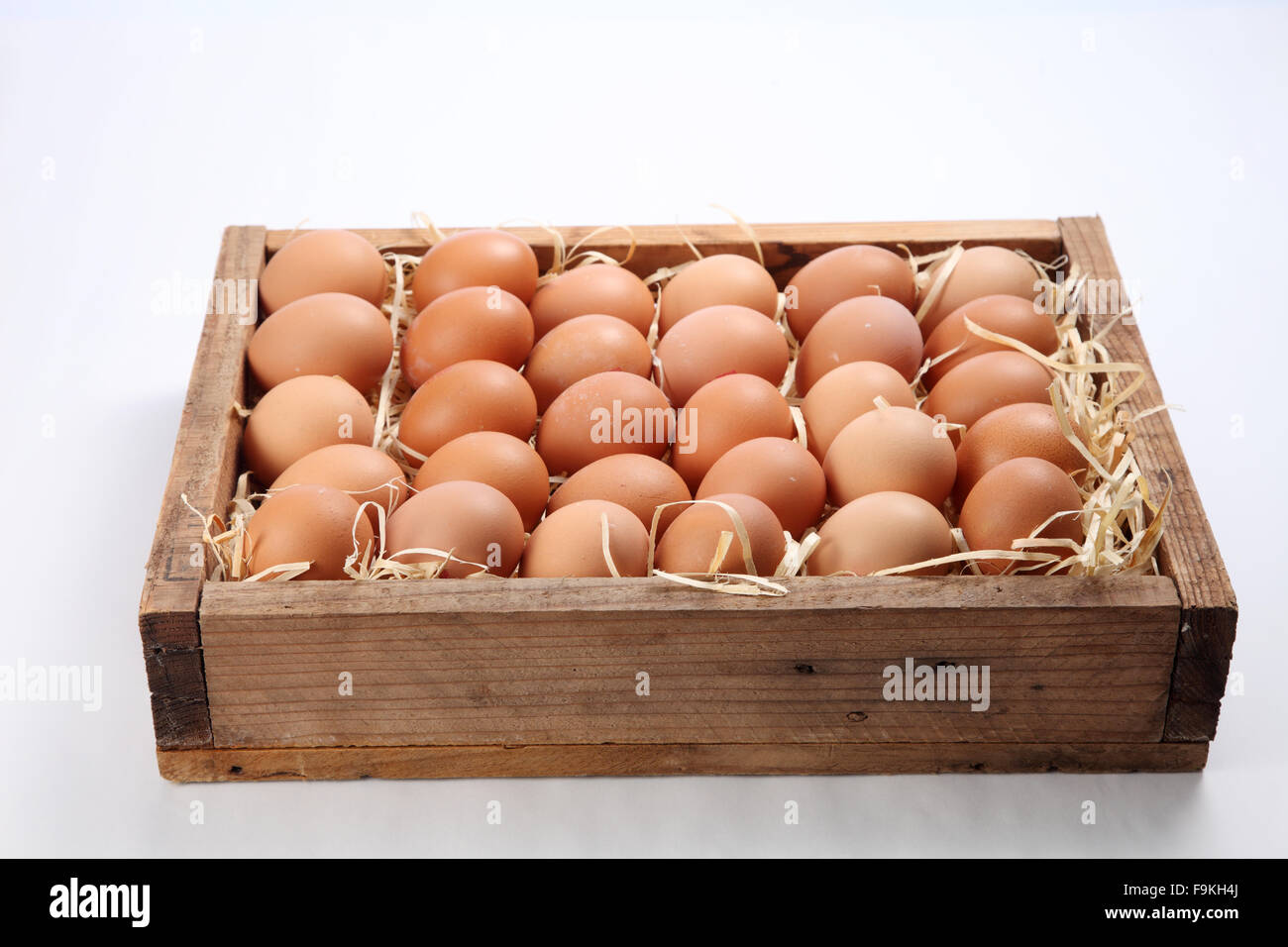bunch of fresh brown eggs and some straw in a wooden crate Stock Photo ...
