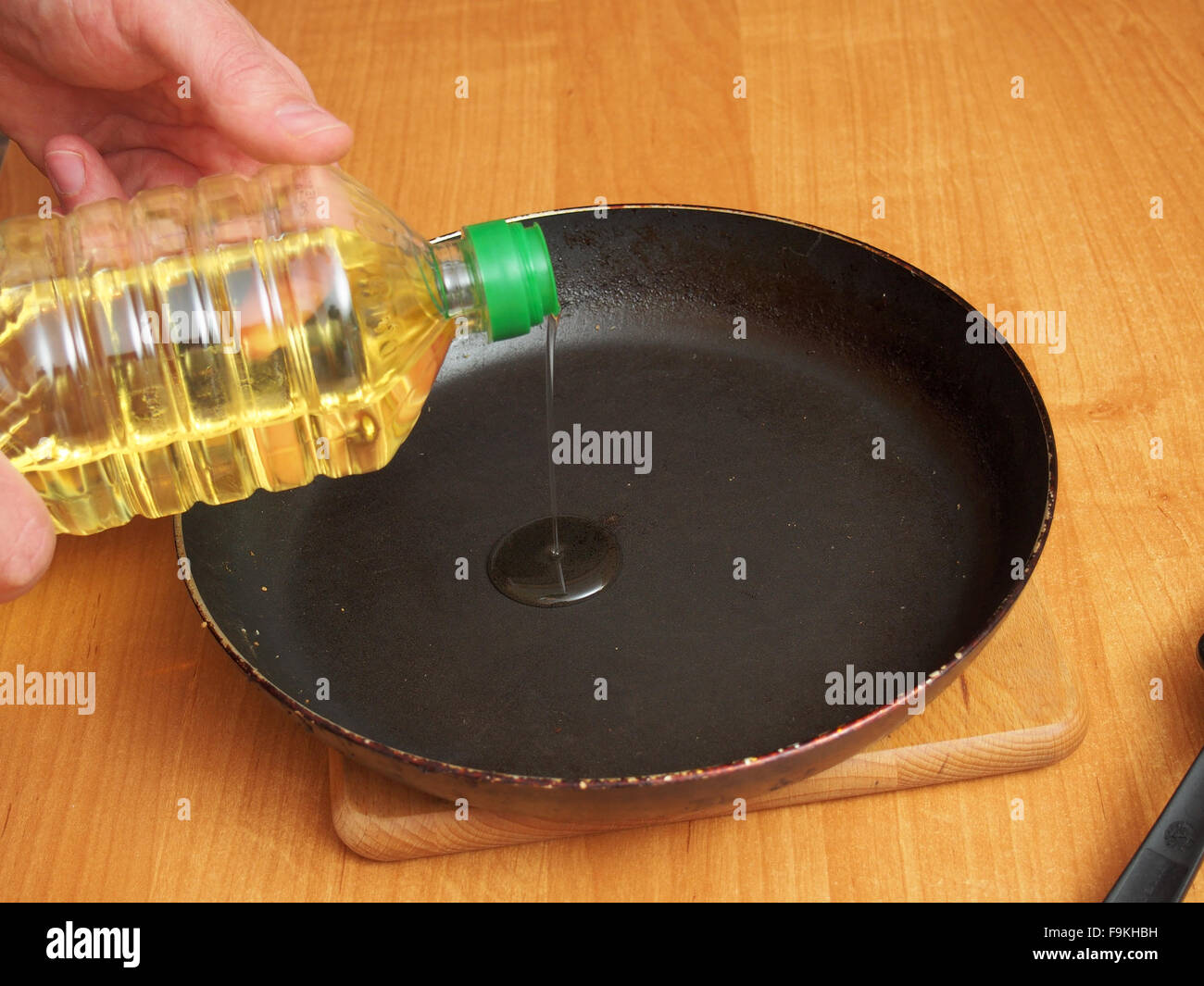Pouring vegetable oil into frying pan. Making yeast pancakes (crepes ...