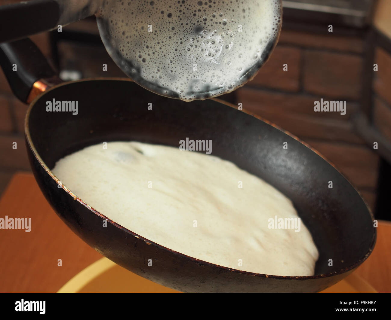 Pouring batter with a ladle. Making yeast pancakes (crepes Stock Photo ...