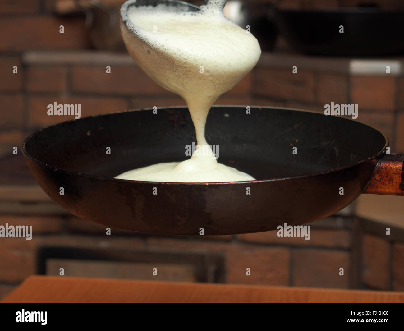 Pouring batter with a ladle. Making yeast pancakes (crepes Stock Photo ...