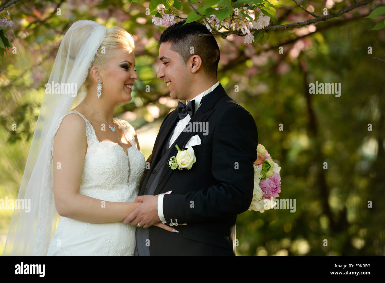 Happy bridal couple on wedding day embracing in nature Stock Photo - Alamy