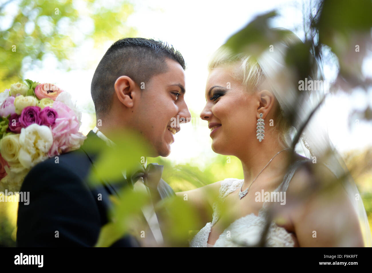Happy bridal couple on wedding day embracing in nature Stock Photo - Alamy