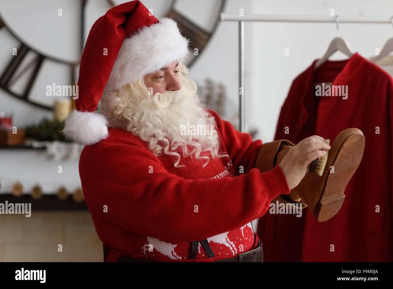 Santa Claus at Home cleaning his Shoes, Preparing for Work Stock Photo ...