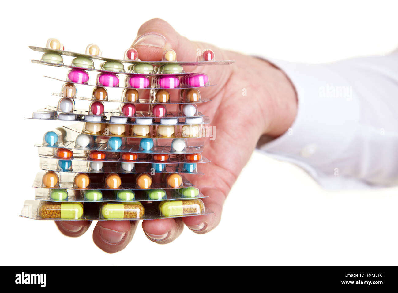 Hand holding a stack of many different pills Stock Photo - Alamy