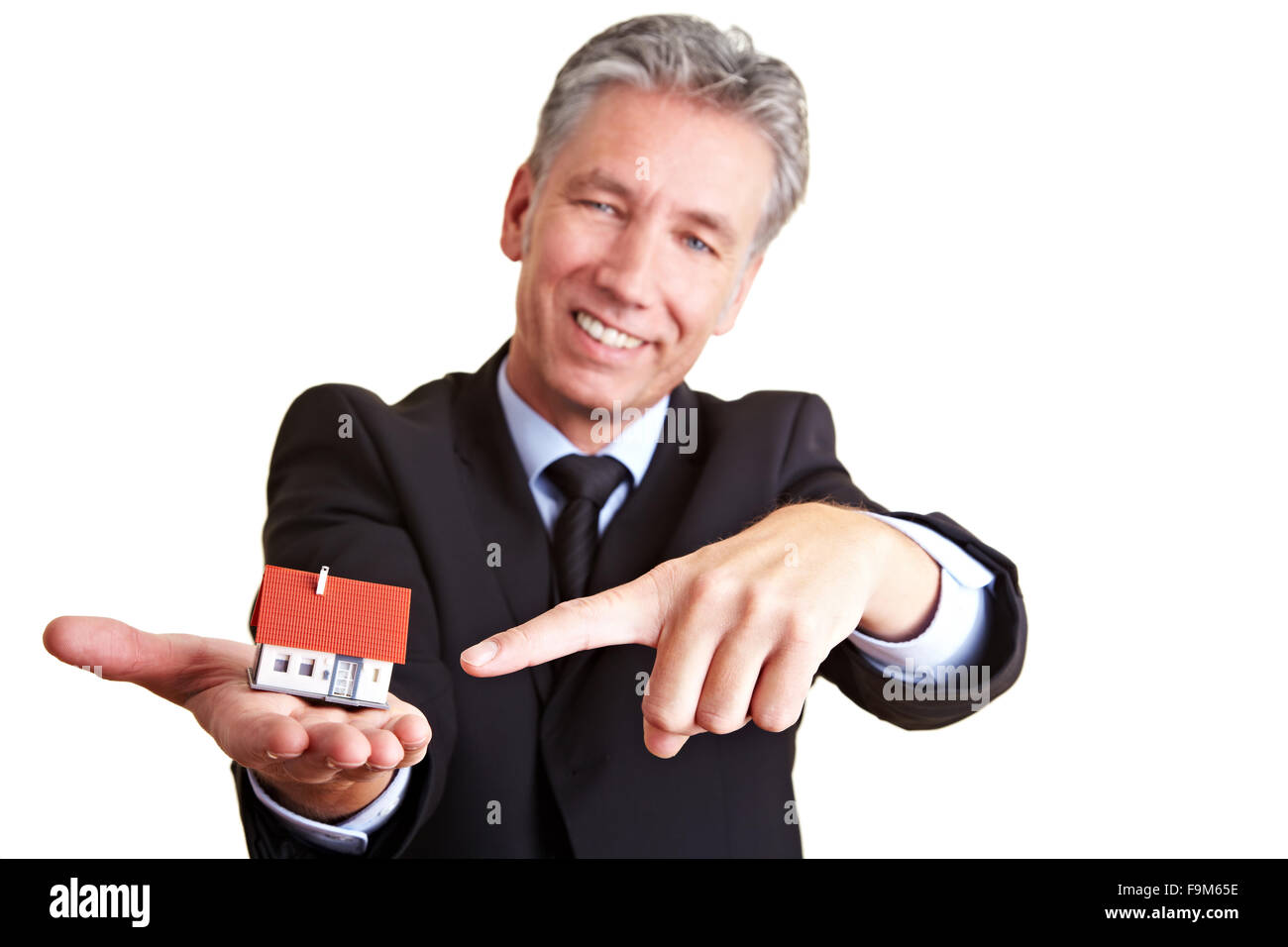 Senior real estate broker offering a small house Stock Photo - Alamy