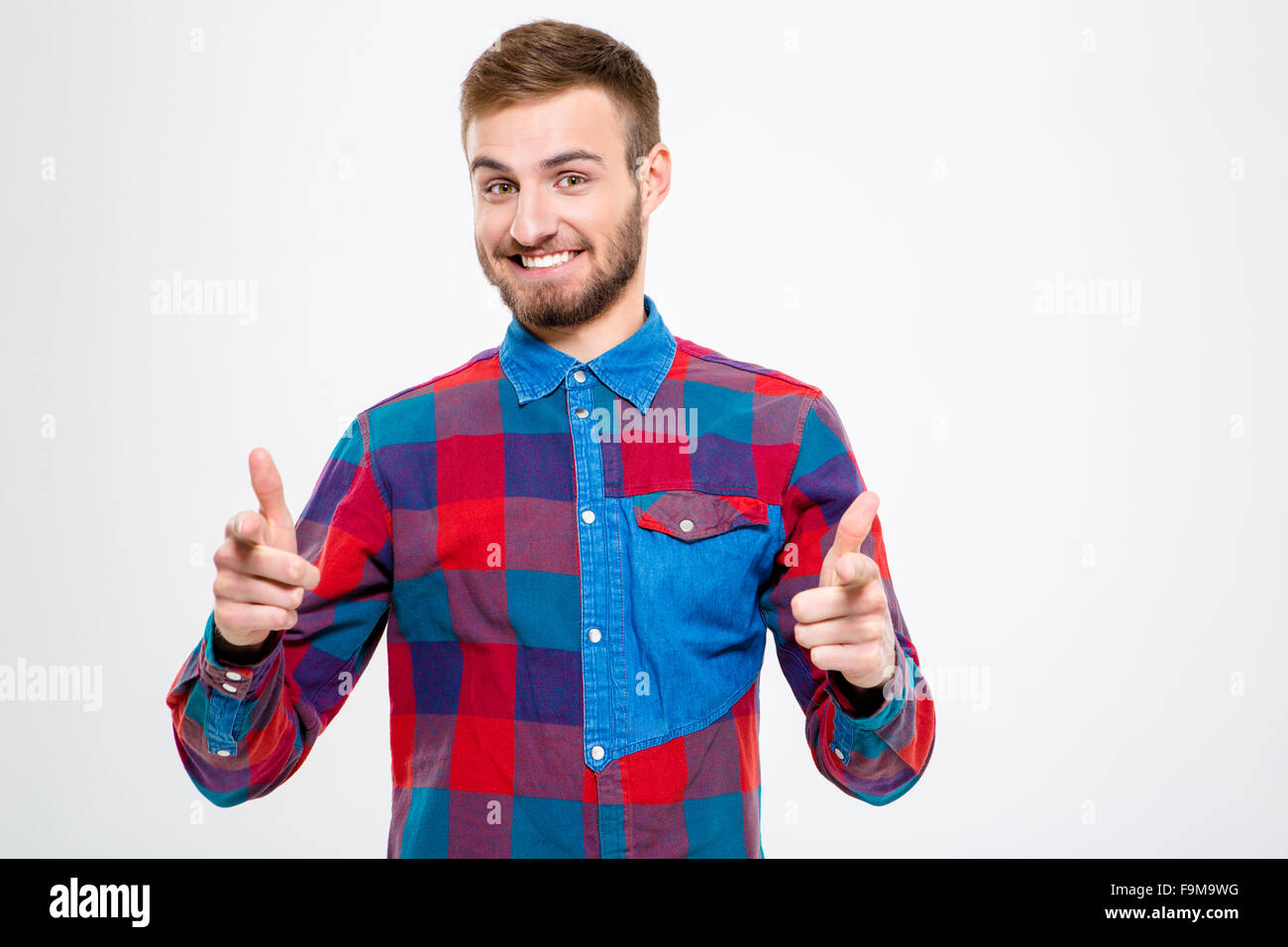 Portrait of a smiling man pointing finger at camera isolated on a white ...