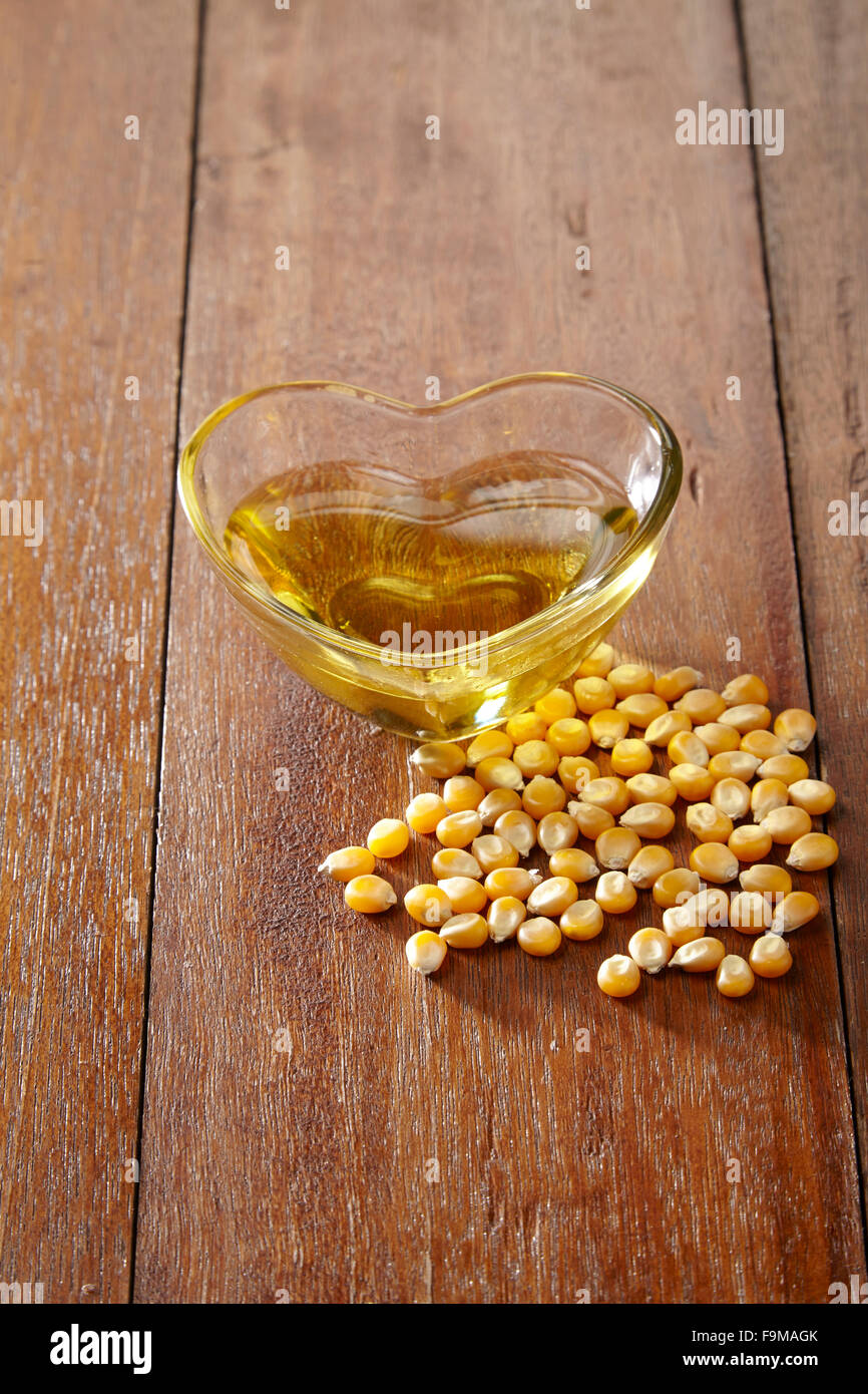 maize corn and glass of heart shape container filled up with corn oil ...