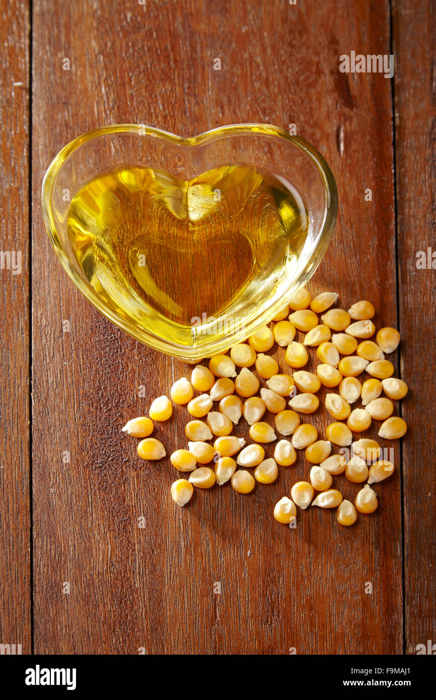 maize corn and glass of heart shape container filled up with corn oil ...