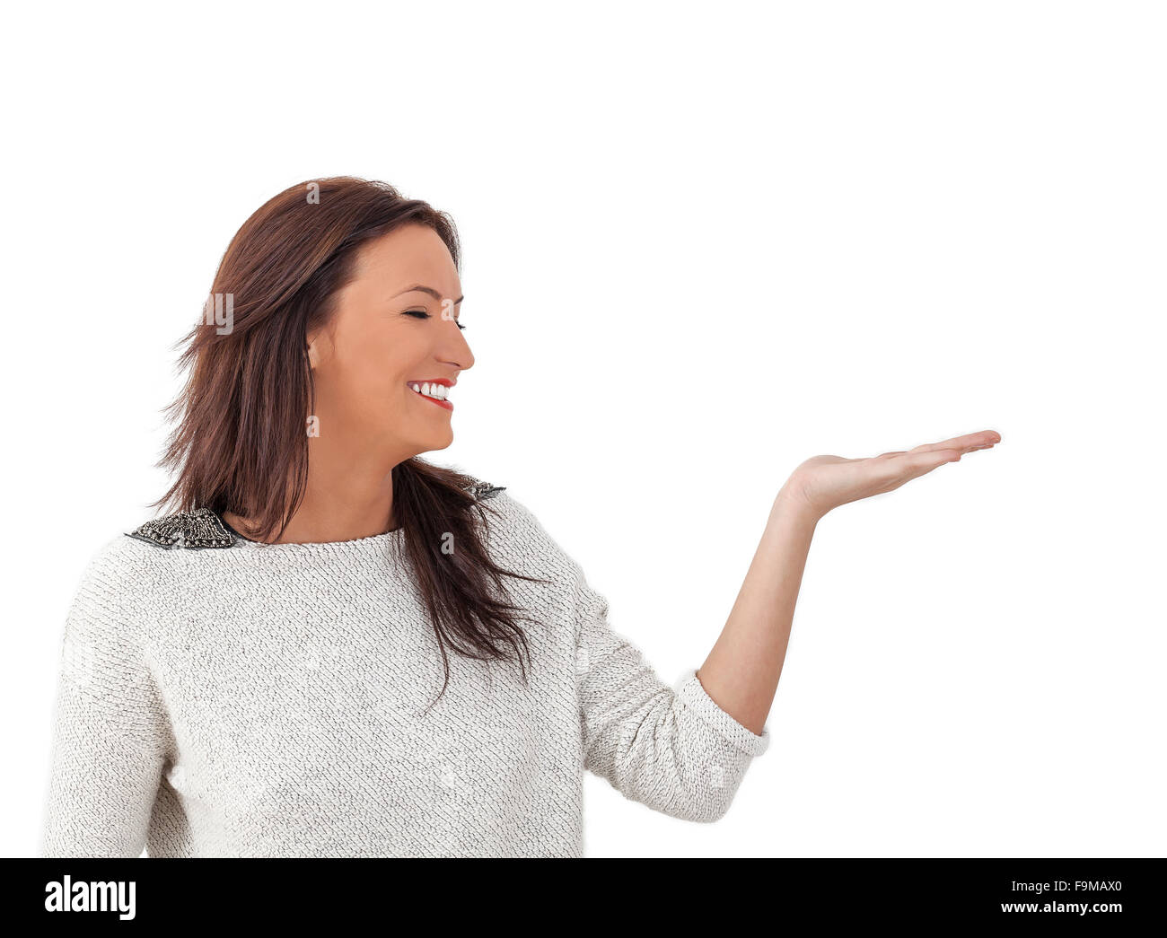 Young smiling woman holding out her hand as if she were displaying ...