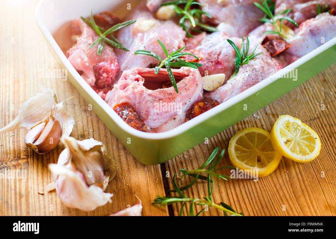 Raw fresh rabbit meat with salt, pepper, rosemary leaves and garlic, on ...