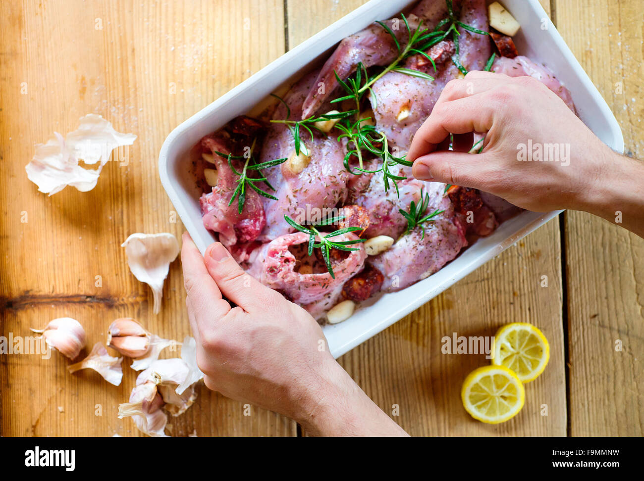 Raw fresh rabbit meat with salt, pepper, rosemary leaves and garlic, on ...
