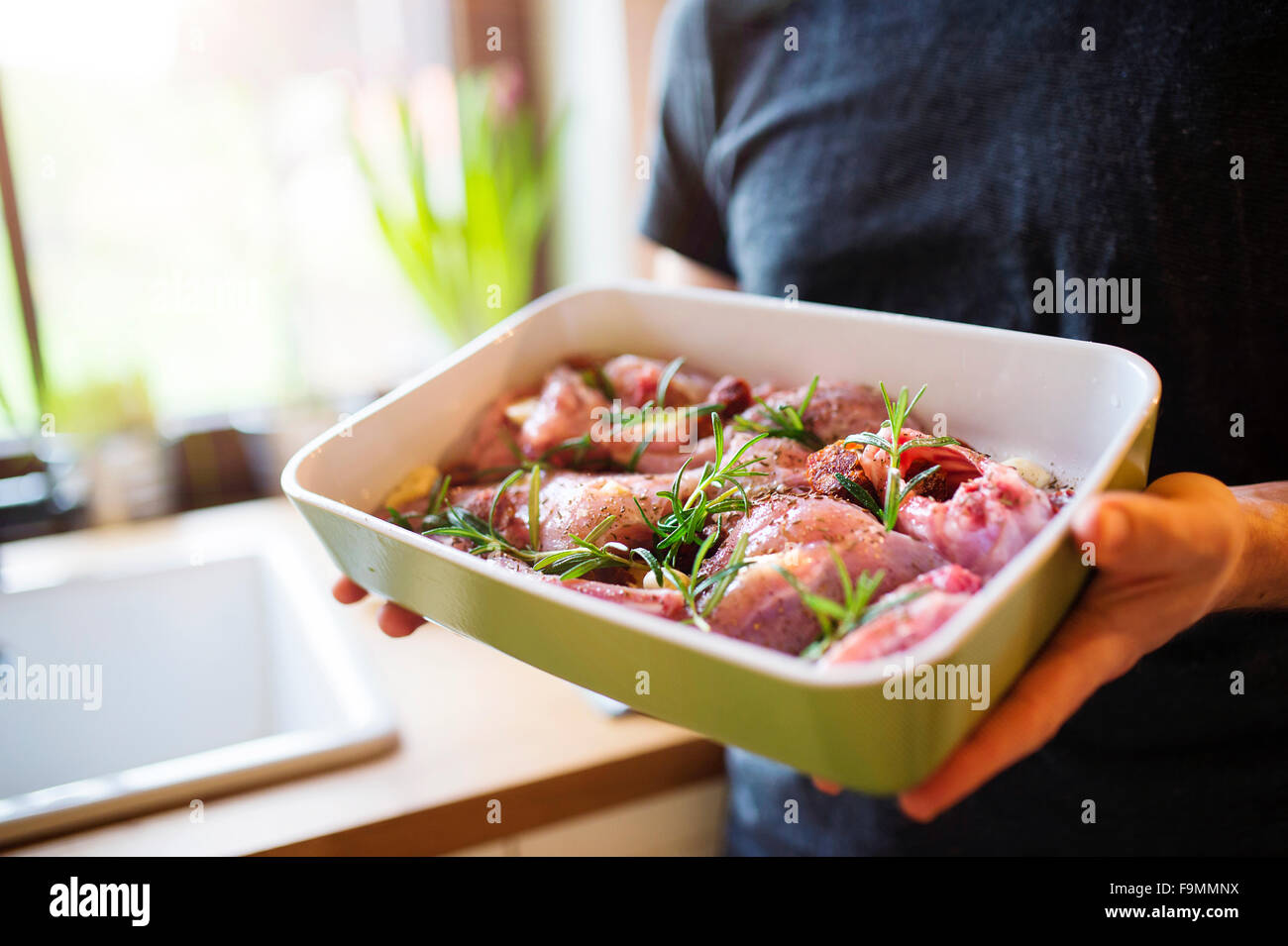 Raw fresh rabbit meat with salt, pepper, rosemary leaves and garlic, on ...