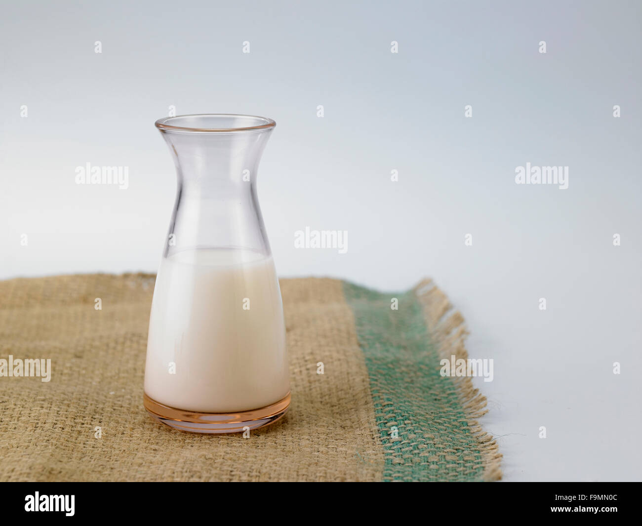 Milk jug over rustic sack cloth background Stock Photo - Alamy
